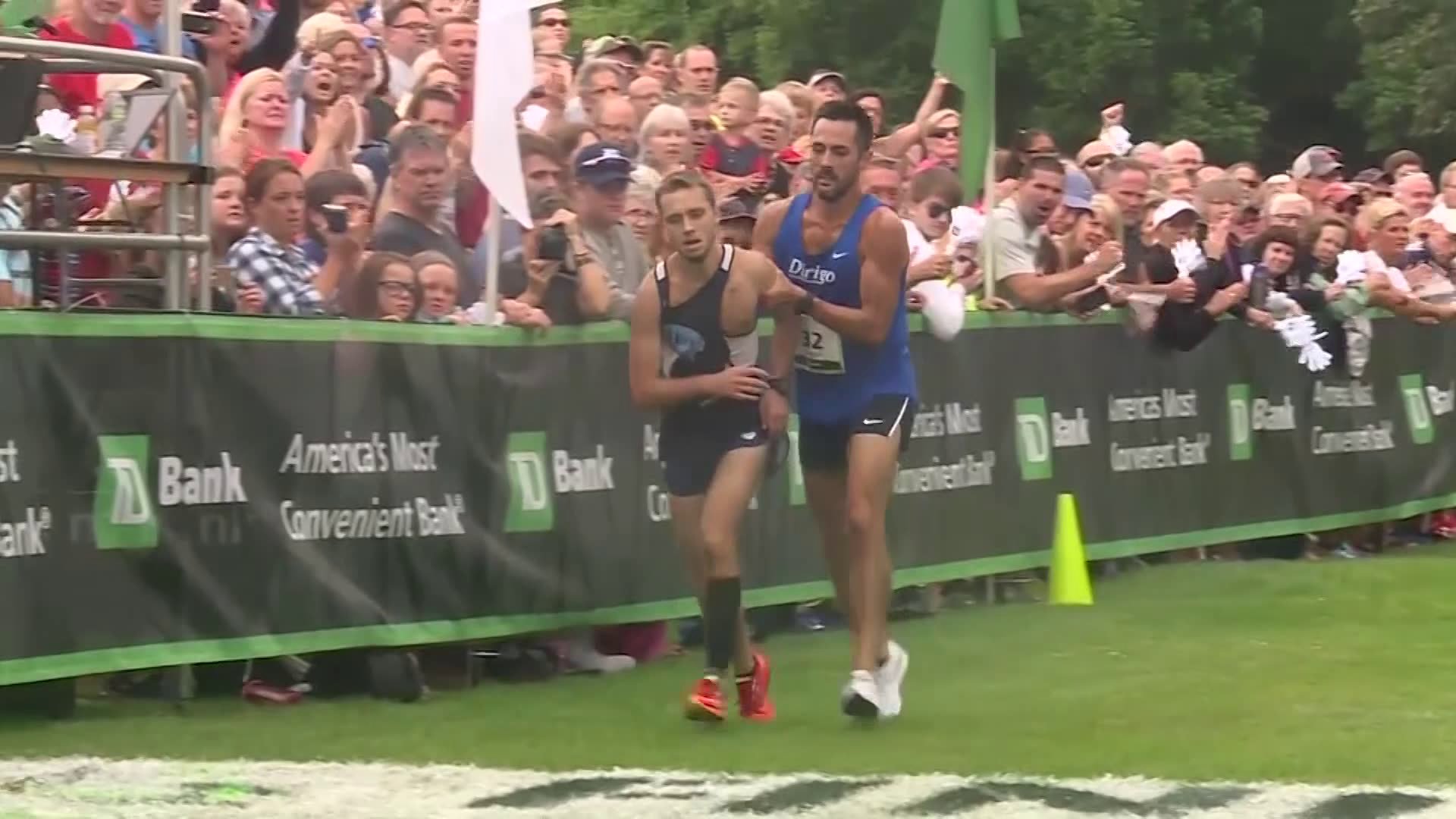 Runner picks up fallen competitor, pushes him across finish line