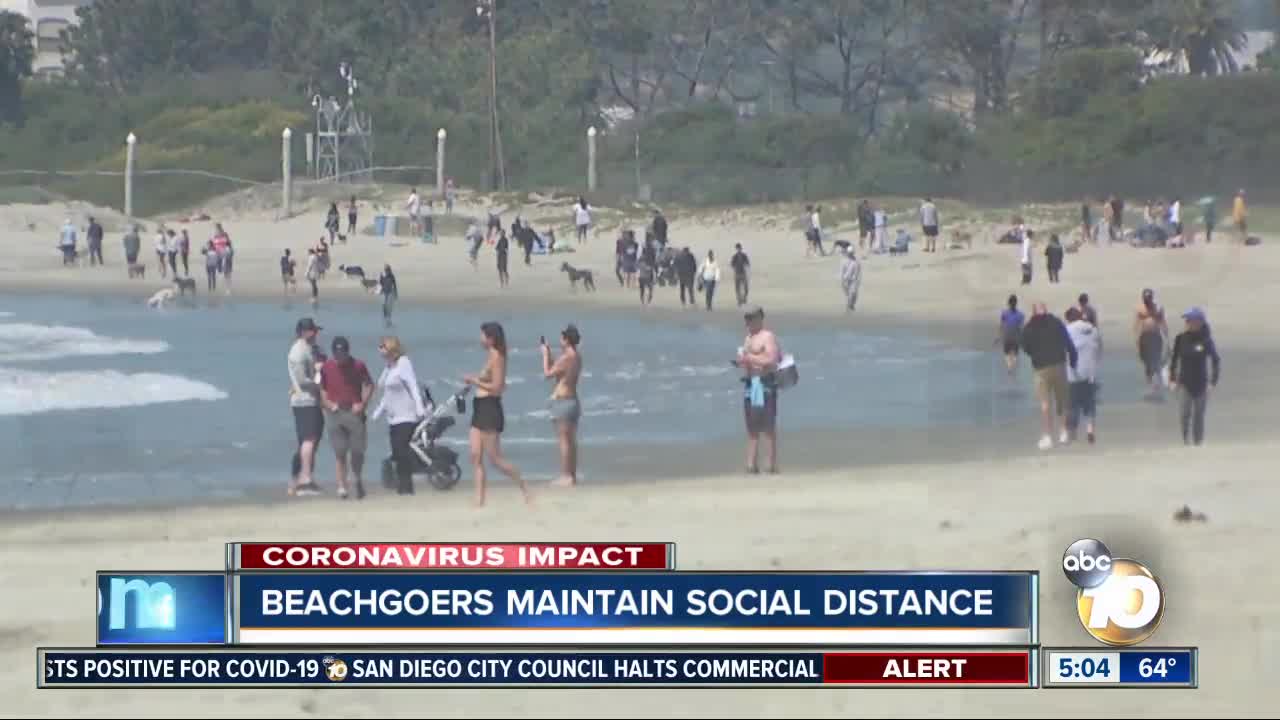 Visitors at still-open beaches maintain social distance